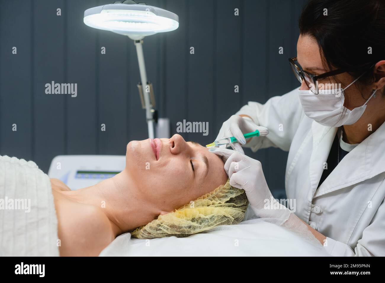 Professional beautician apply skin injections in female forehead, anti ...
