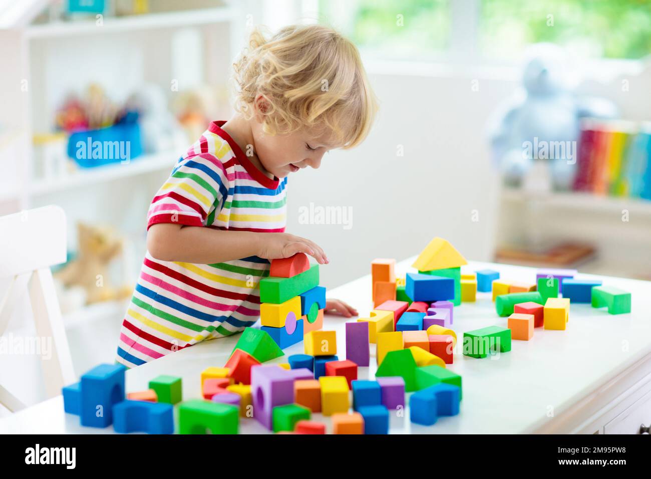 Kid playing with colorful toy blocks. Little boy building tower of ...