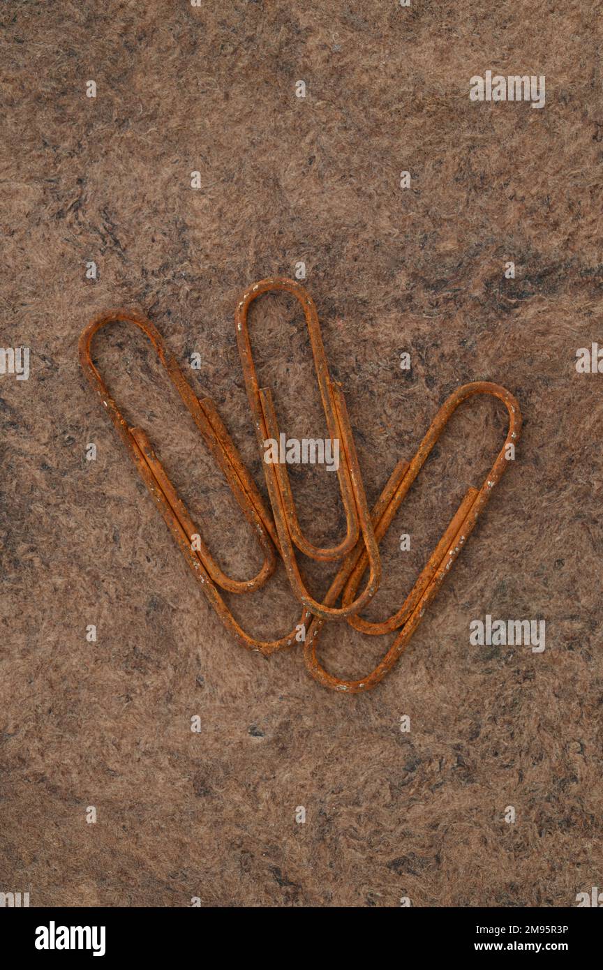 Three rusty paper clips lying on old leather Stock Photo - Alamy