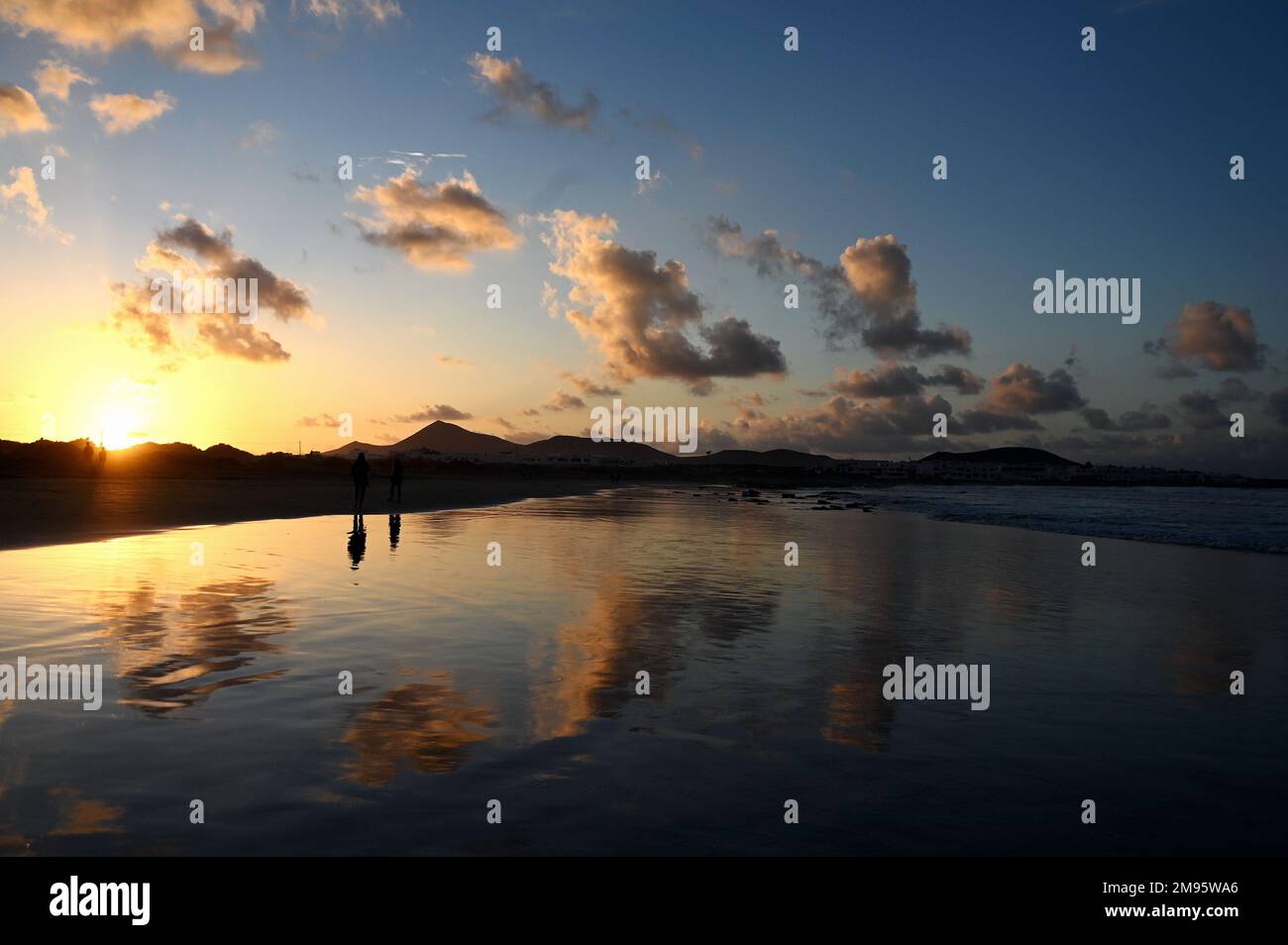 Sunset reflected on the beach of Caleta de Famara, Playa de Famara ...
