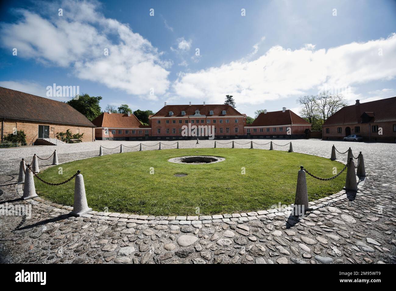 A scene of the Moesgaard Museum with a beautiful yard surrounded by red ...