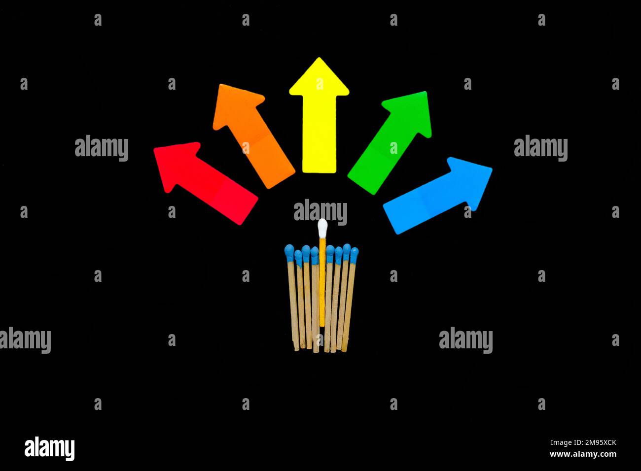 Multi-colored matches on a black background with arrows symbolizing the ...