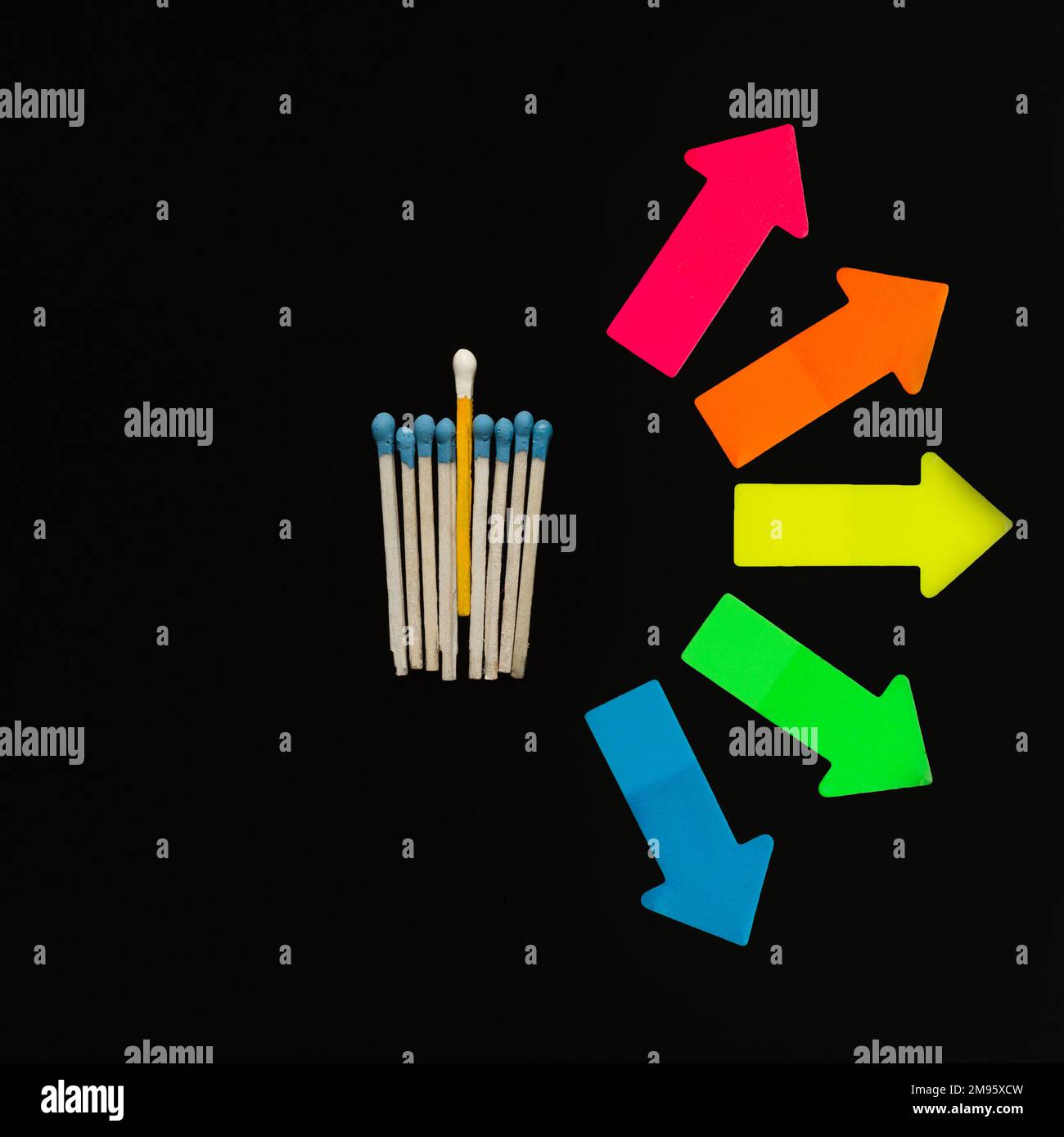 Multi-colored matches on a black background with arrows symbolizing the ...
