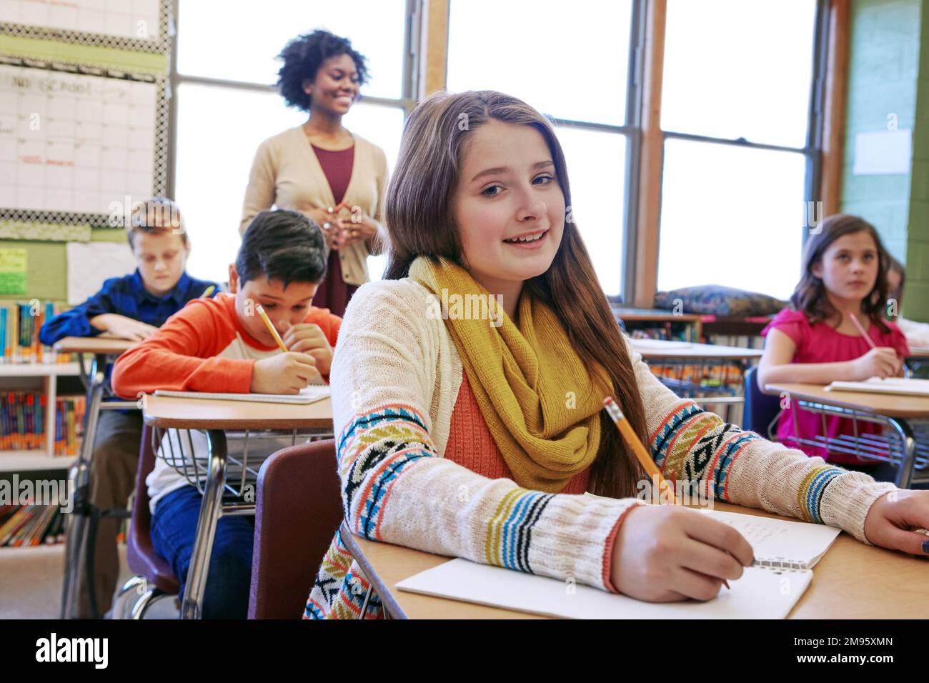 Portrait, girl in classroom and writing with smile, learning and ...