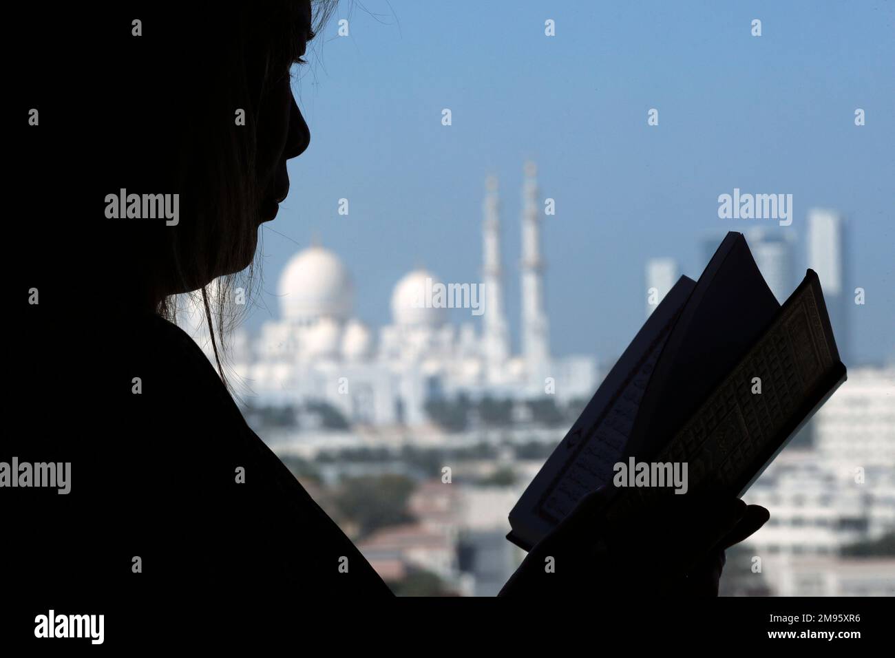 Silhouette of a Muslim woman reading the Holy Quran. Sheikh Zayed Grand ...