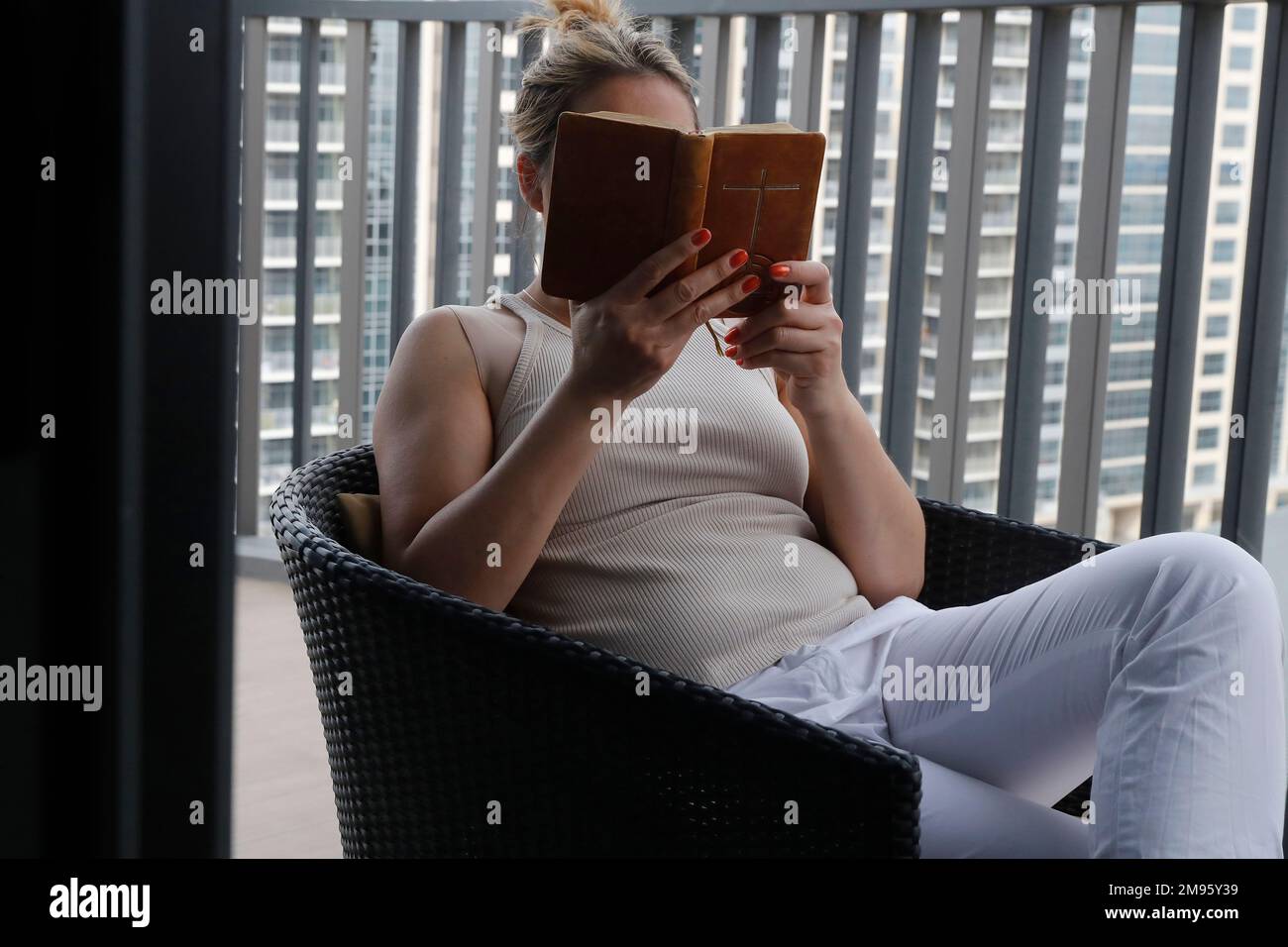Woman reading the bible on a balcony Stock Photo - Alamy