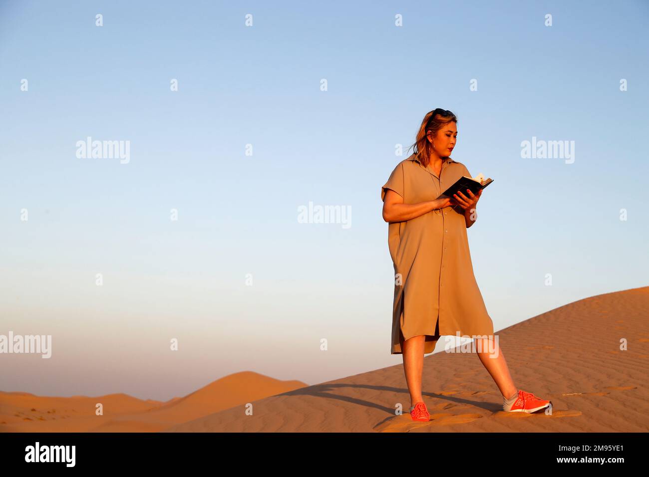 Christian woman reading the bible in desert sand dune. Concept for ...