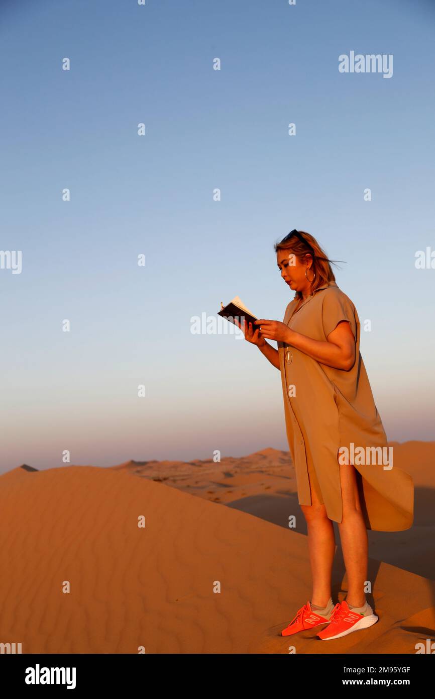 Christian woman reading the bible in desert sand dune. Concept for ...