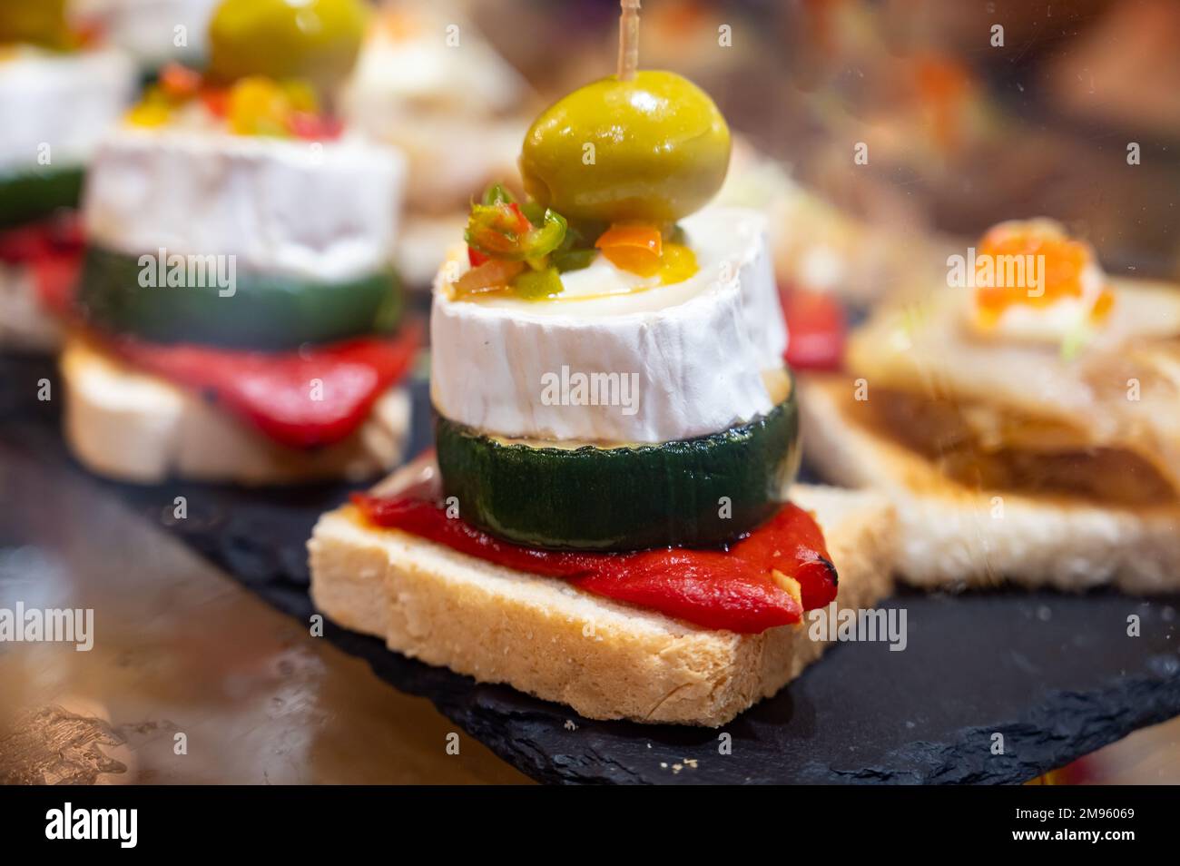 Typical snack of Basque Country, pinchos or pinxtos skewers with small ...