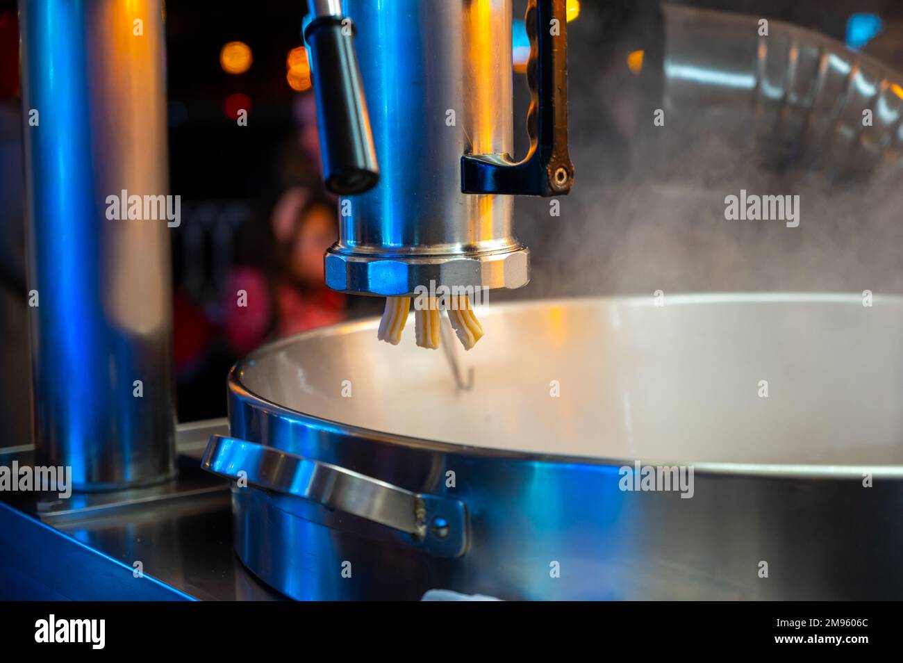 Machine for making sweet Spanish dessert churros sticks on night ...