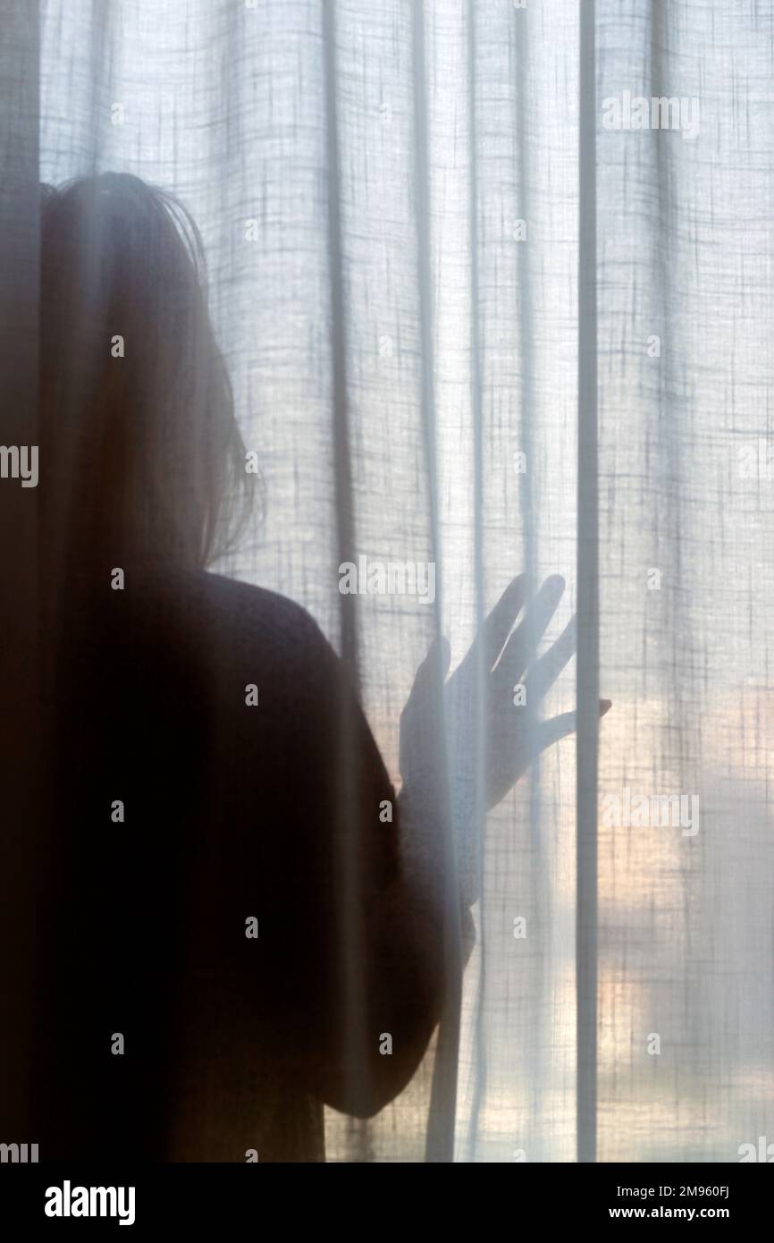Silhouette of a woman behind a semi transparent curtain. Depression ...