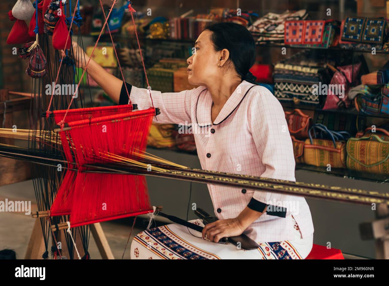 MUI NE, VIETNAM - MARCH 6, 2017: Female weaver works behind traditional ...