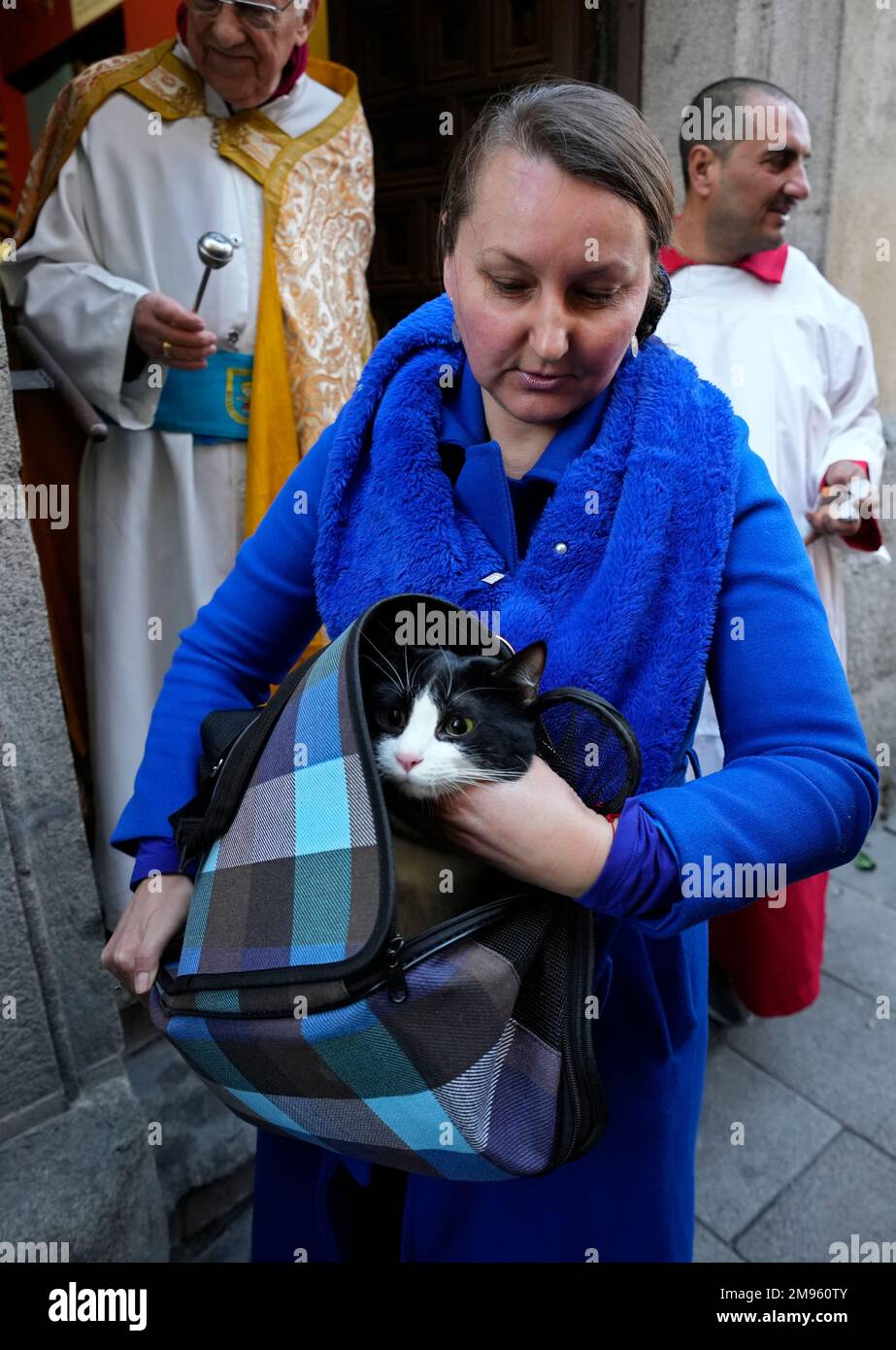 A woman carries a cat in a bag after it was anointed by a priest at the ...