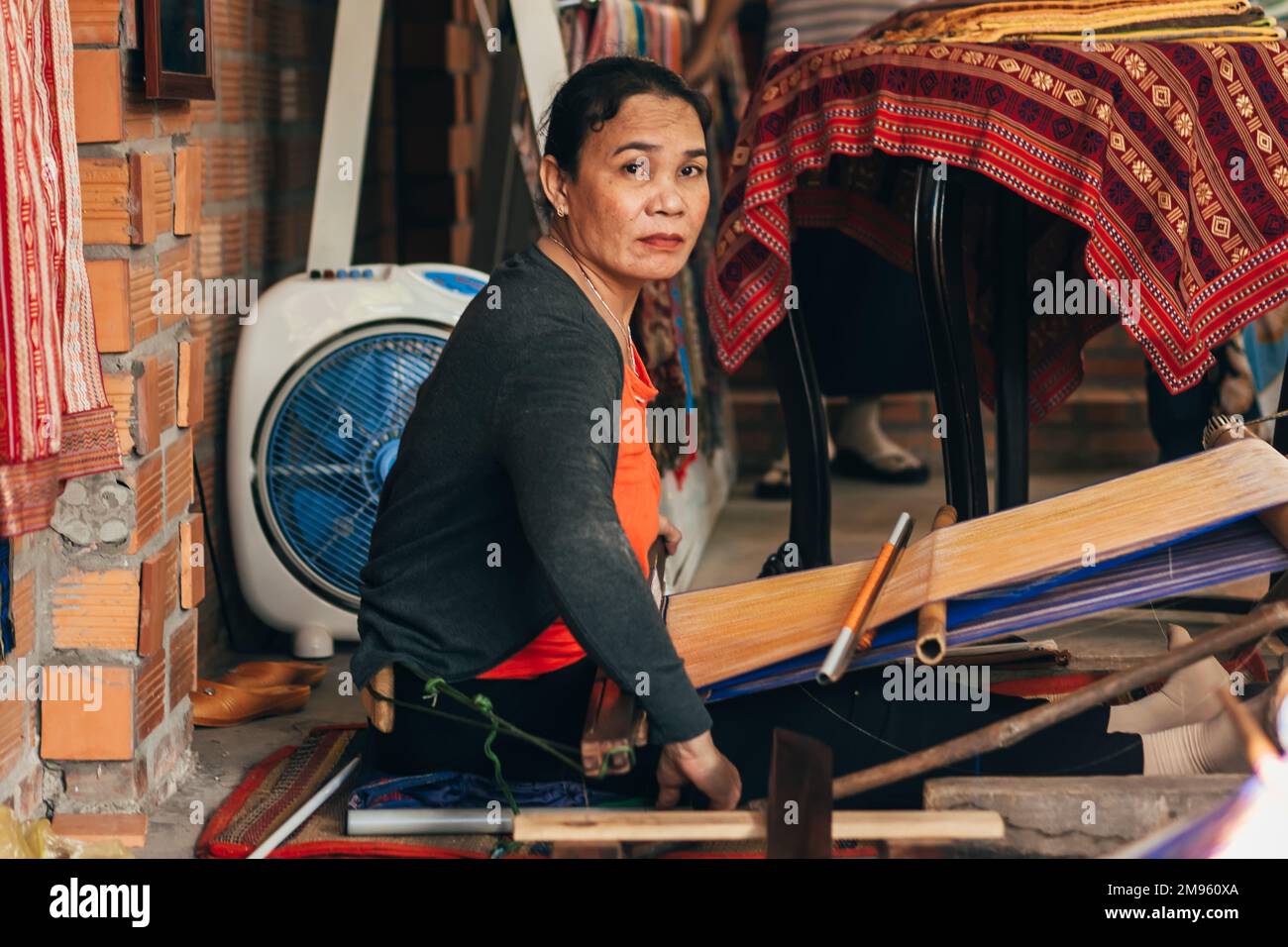 MUI NE, VIETNAM - MARCH 6, 2017: Female weaver working at a traditional ...