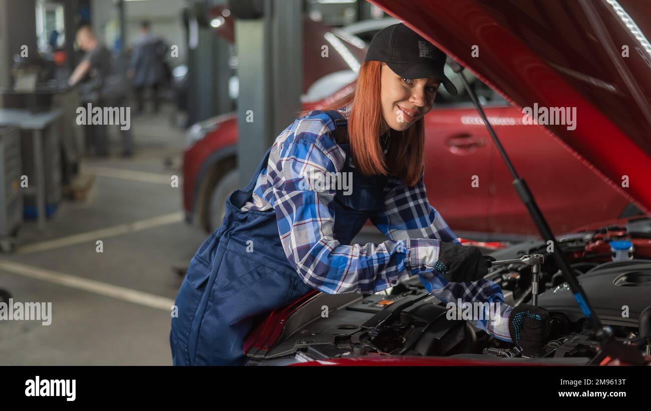 A woman auto mechanic in overalls is repairing a car Stock Photo - Alamy