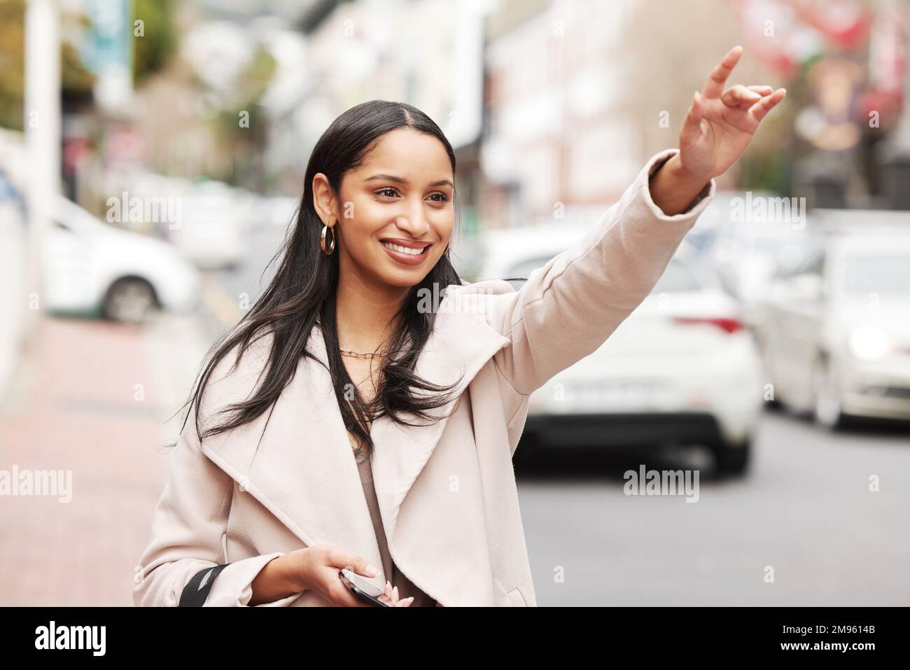 Ready to go home now. a young woman hailing a cab after shopping Stock ...