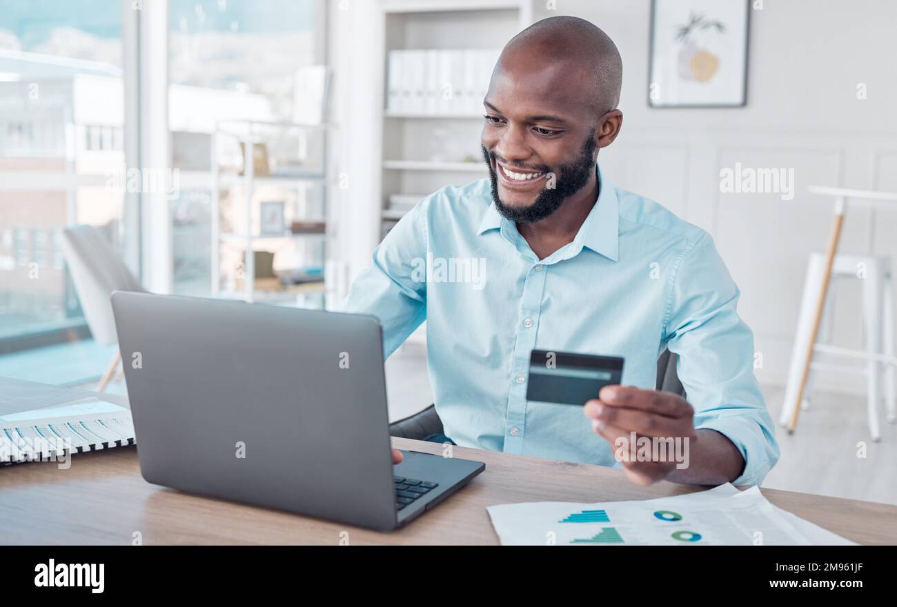 Money can buy happiness. a young businessman using his laptop to make ...