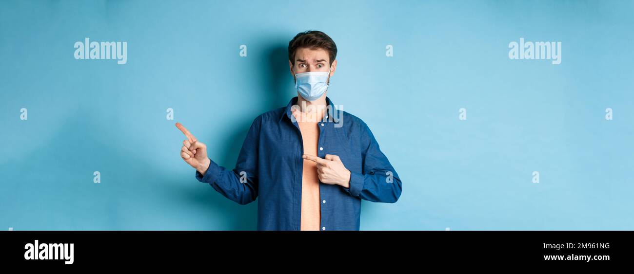 Covid and healthcare concept. Worried young man in medical mask raising ...