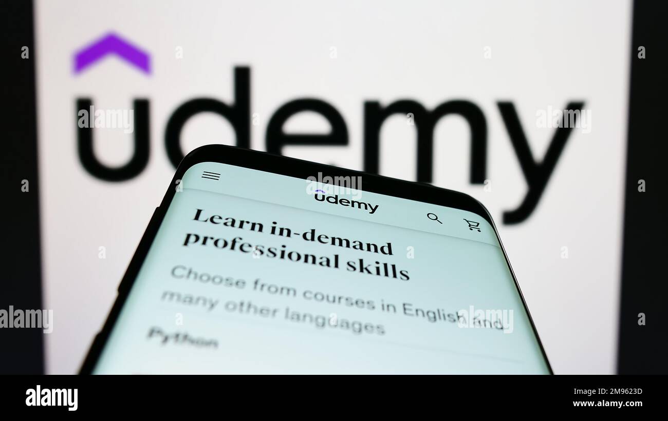 Mobile phone with webpage of US online education company Udemy Inc. on screen in front of ...