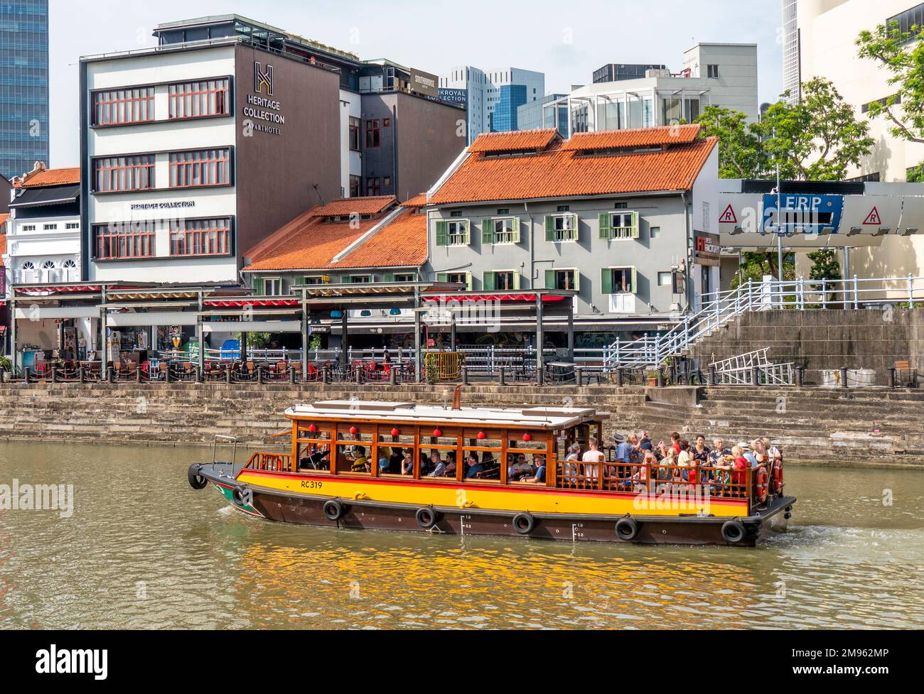 Tourism ferry chugging along the Singapore River at Boat Quay Singapore ...