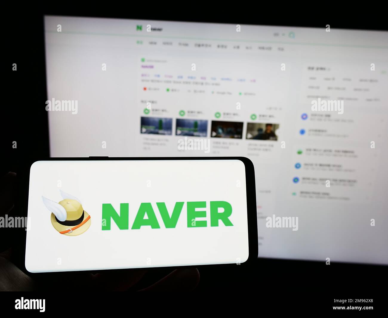 Person holding mobile phone with logo of search engine company Naver ...