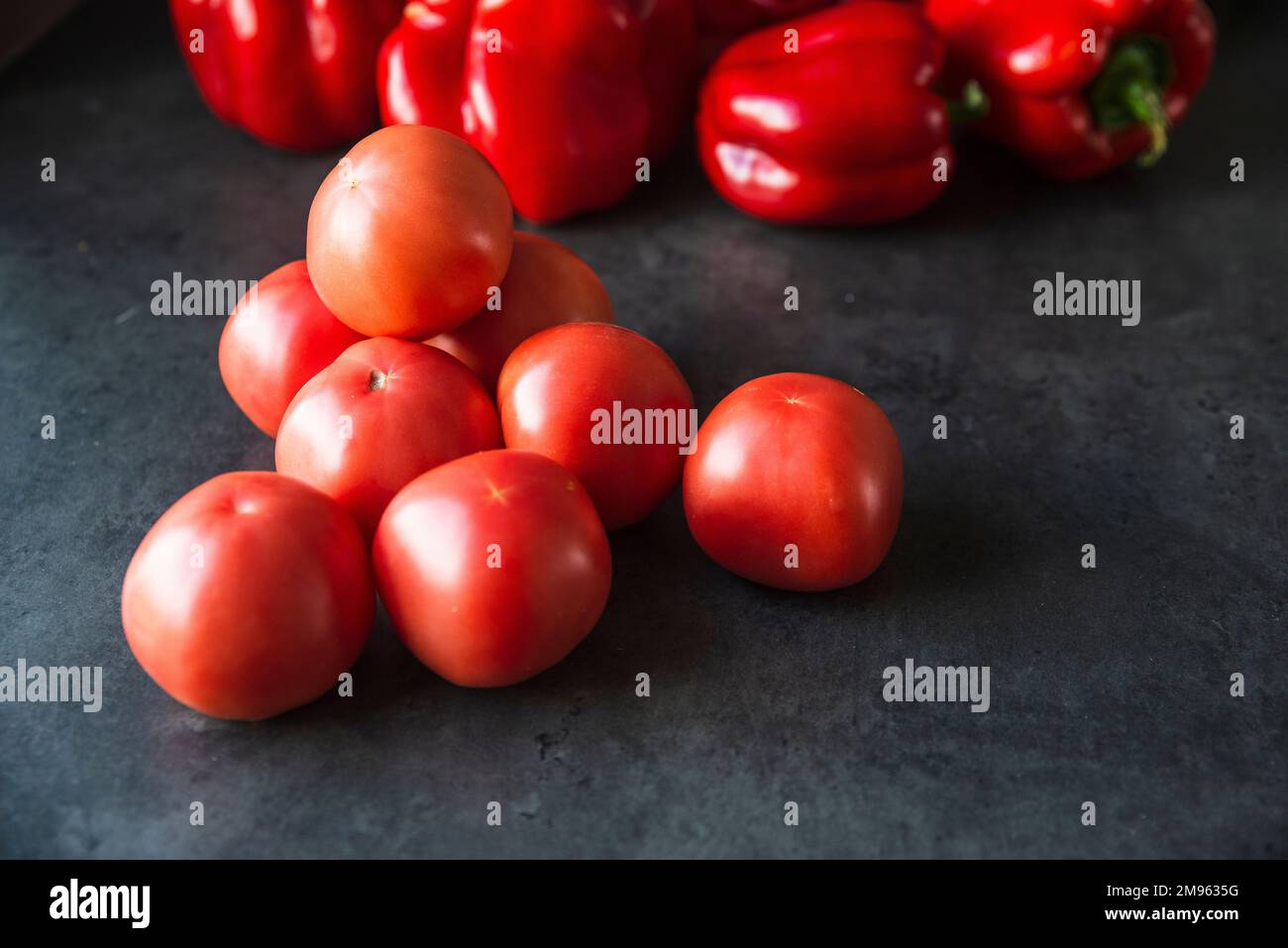 red tomatoes on a dark kitchen counter Stock Photo - Alamy