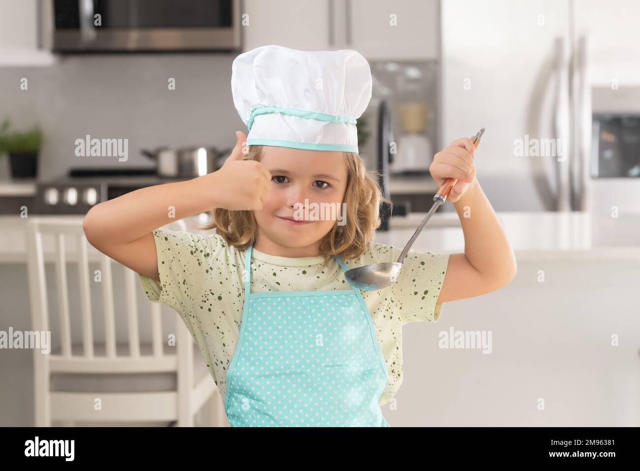 Kid chef cook cookery at kitchen. Cute boy cooking in kitchen at home ...