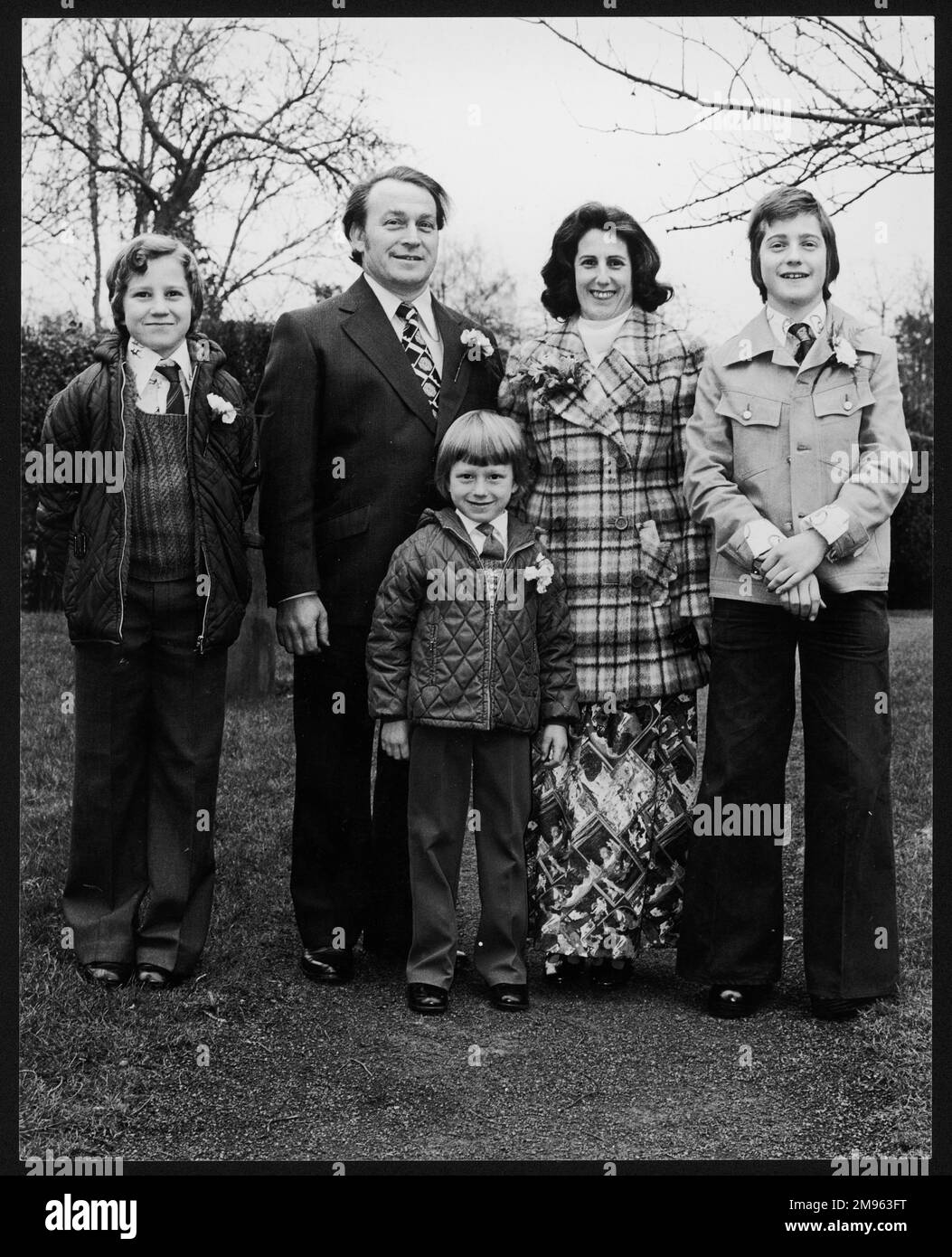 A family with three young sons photographed wearing carnations at a ...
