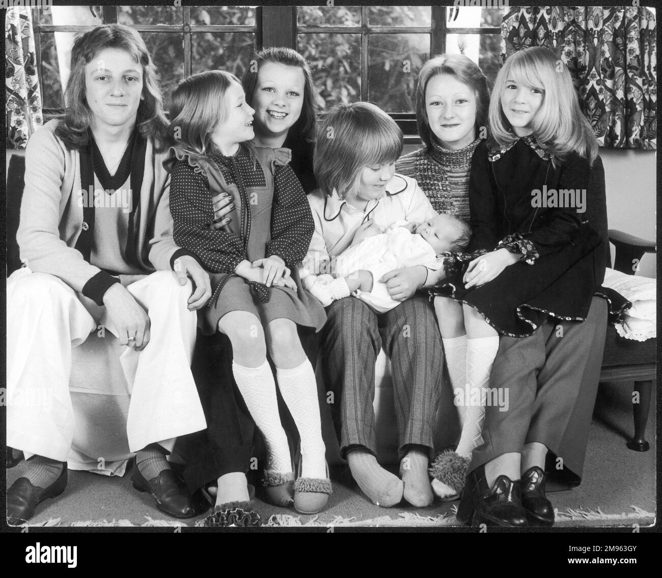 A proud young couple and their five children, including a new baby ...