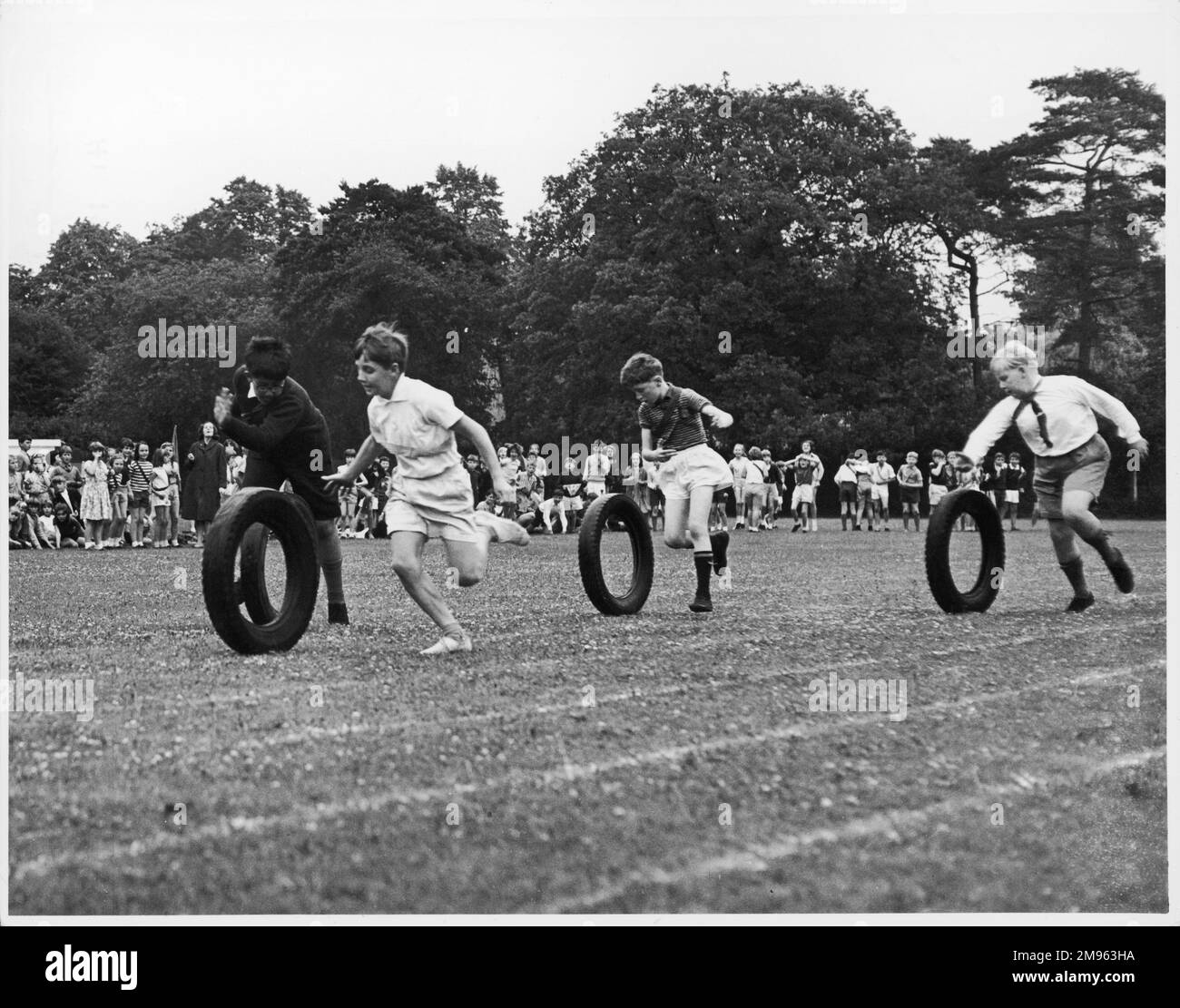 Boys competing in a tyre race Stock Photo - Alamy