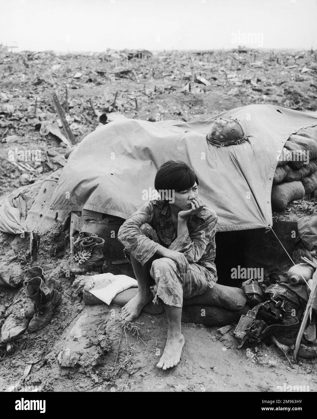 A young, disheartened South Vietnamese soldier rests on a sandbag ...