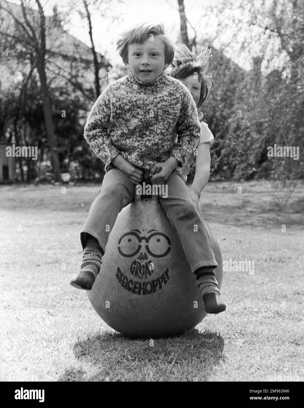A young boy and his friend enjoy a fun afternoon bouncing about on the ...