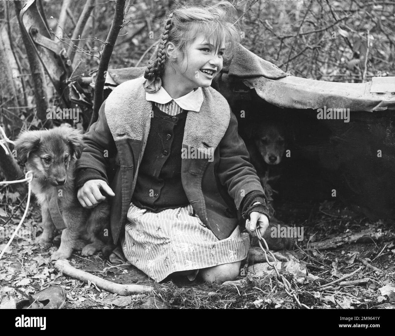 A scruffy but pretty little blonde gipsy girl with her hair in plaits ...