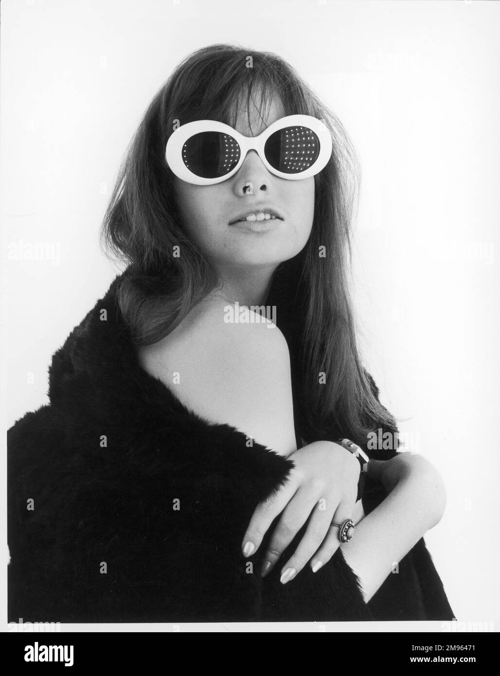 A brunette model wears an off the shoulder fur coat and fab sunglasses ...