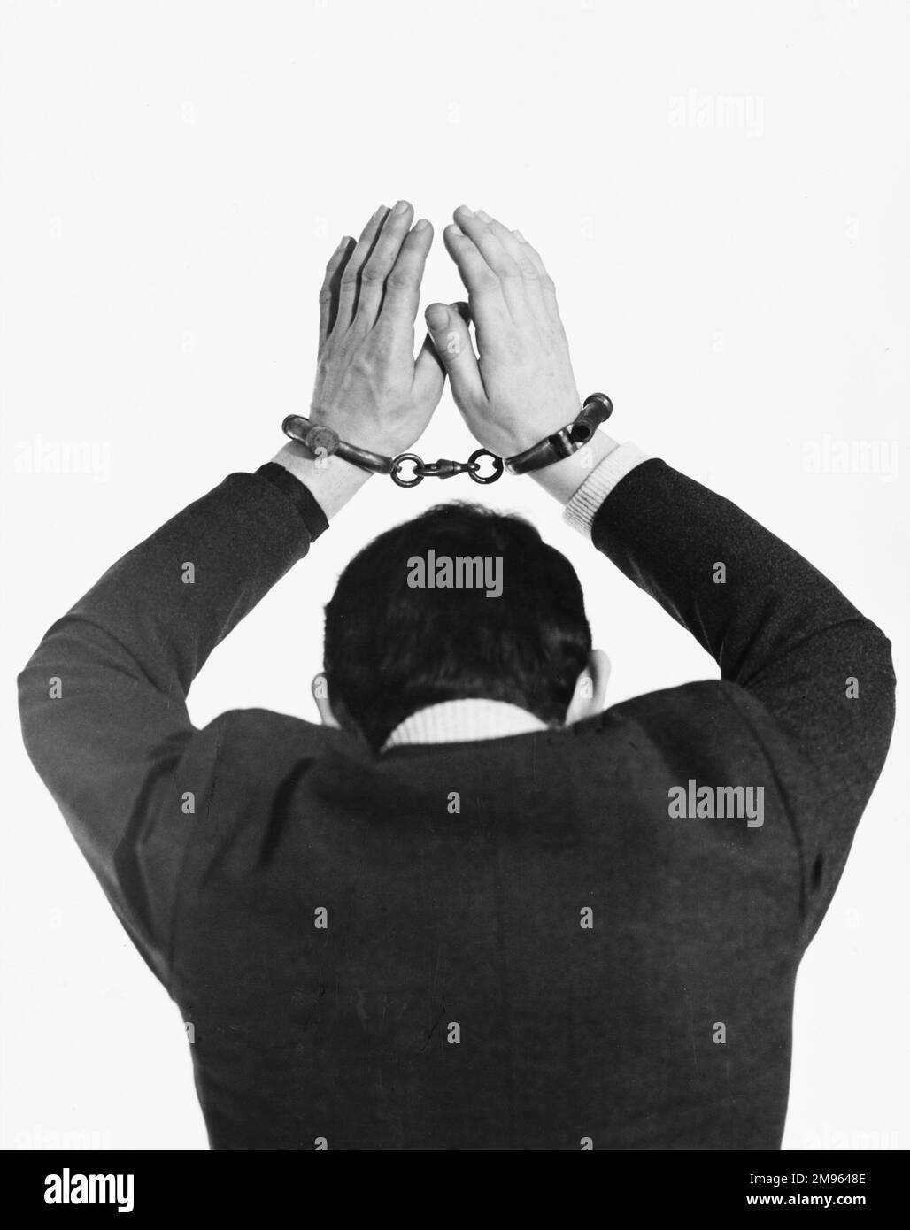 A handcuffed man raises his hands above his head Stock Photo - Alamy