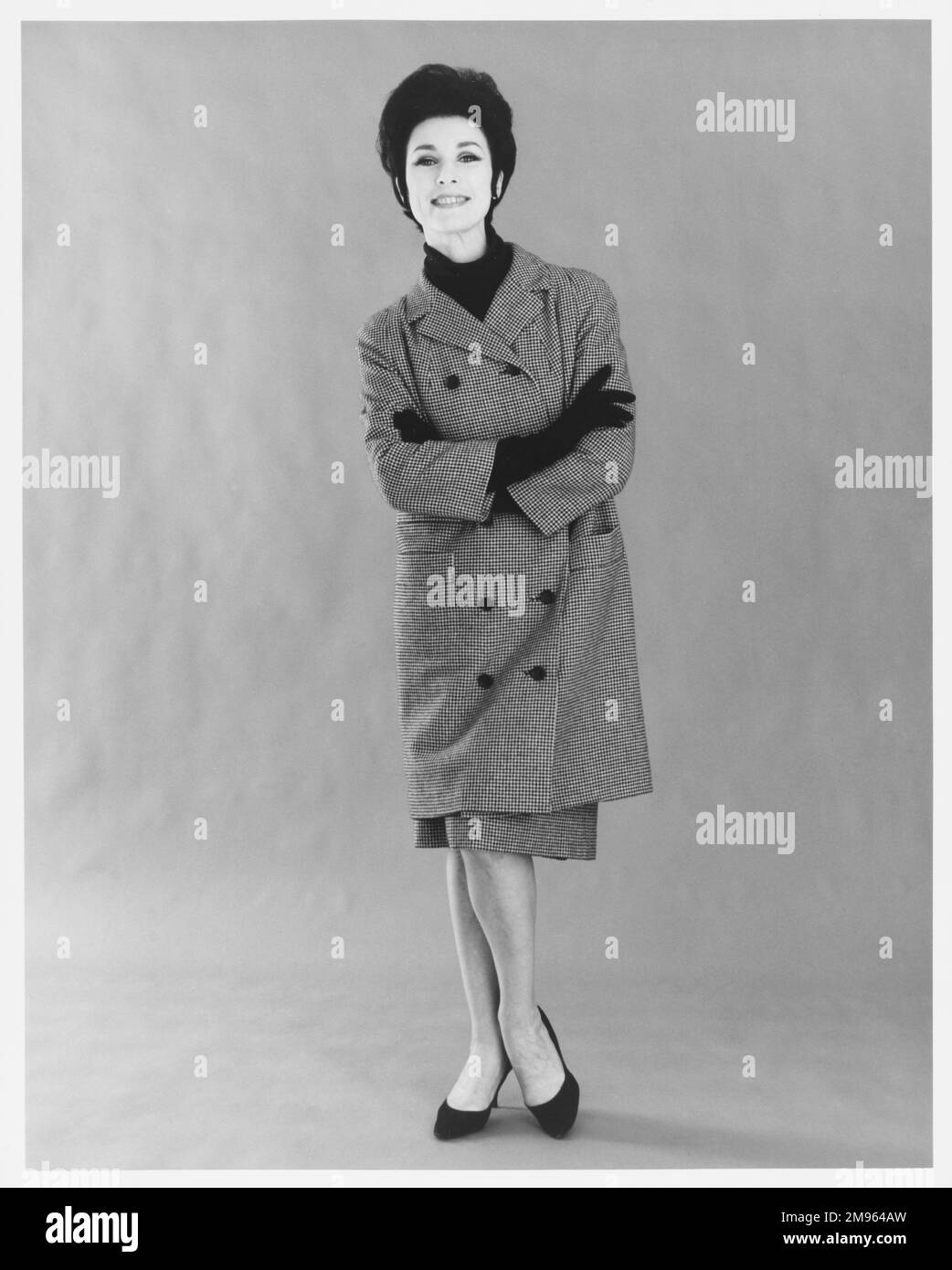 Full-length portrait of a woman in a knee-length coat with matching ...