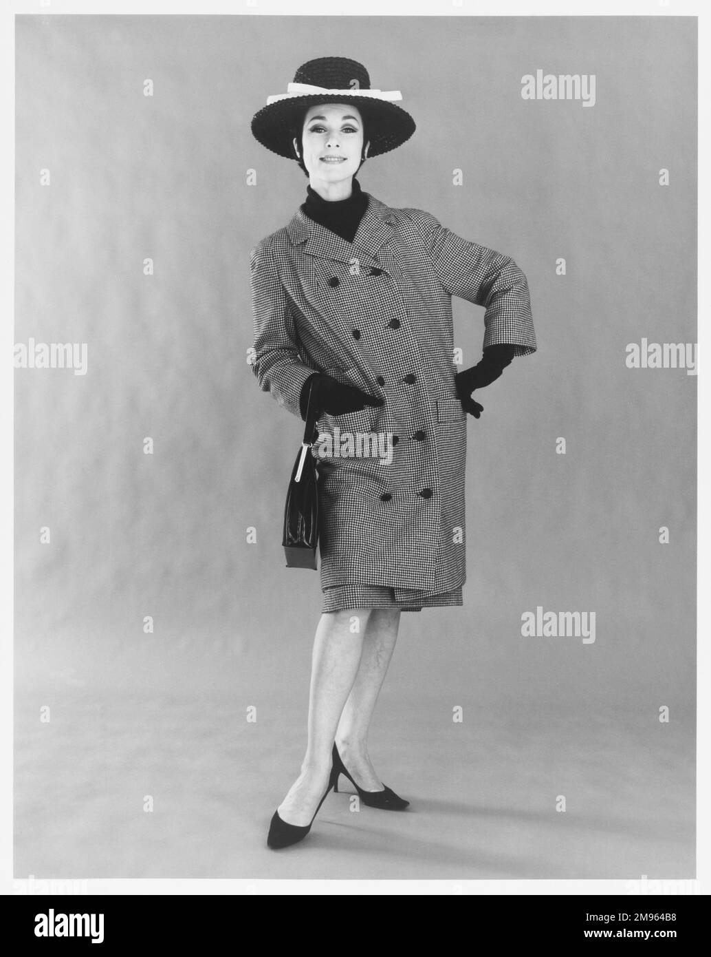 Full-length portrait of a woman in a black hat and knee length coat ...