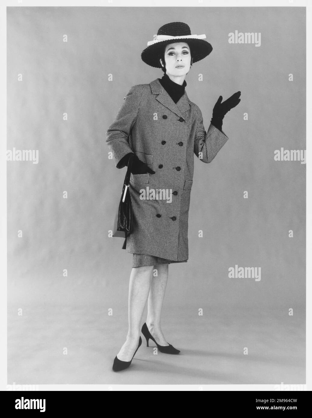 Full-length portrait of a woman in a black hat and knee length coat ...