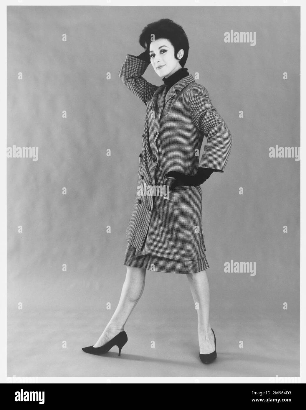Full-length portrait of a woman in a knee-length coat with matching ...
