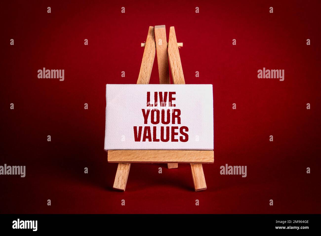 Live your values. Miniature easel with text on a red background Stock ...
