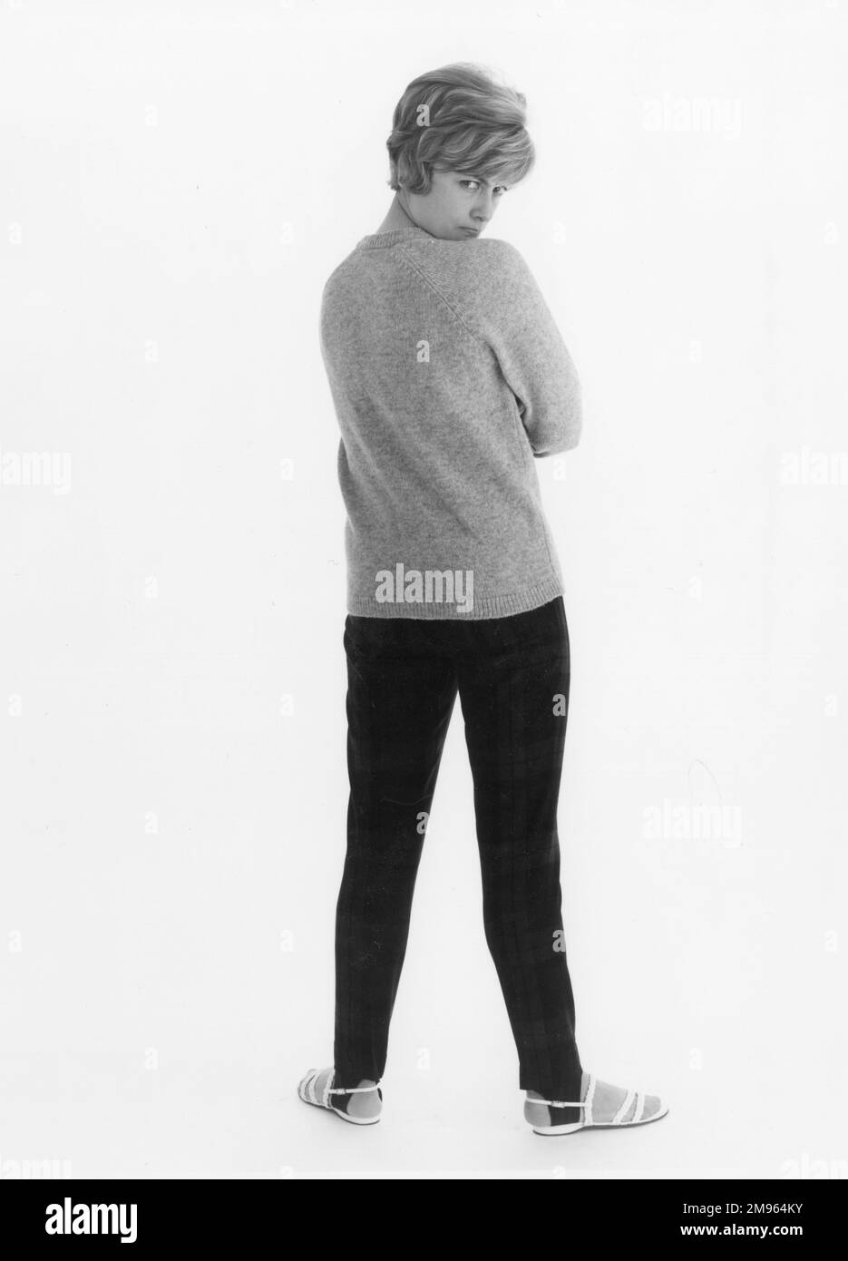 Full length portrait of a woman looking back over her shoulder at the ...