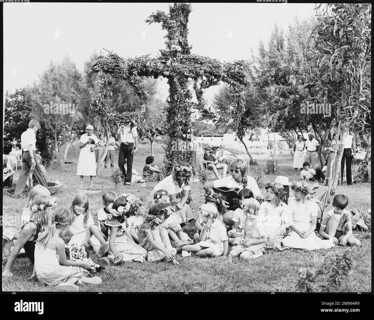 A Scandinavian Midsummer festival, centred around a large cross with ...