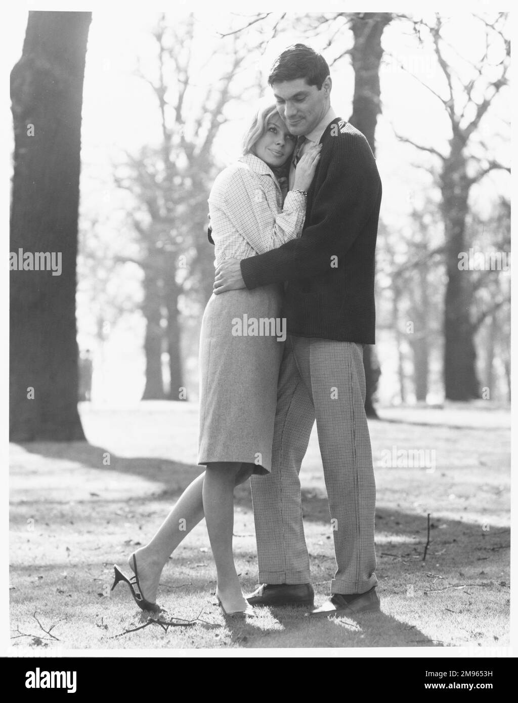 A couple out on a winter walk stop for a hug Stock Photo - Alamy