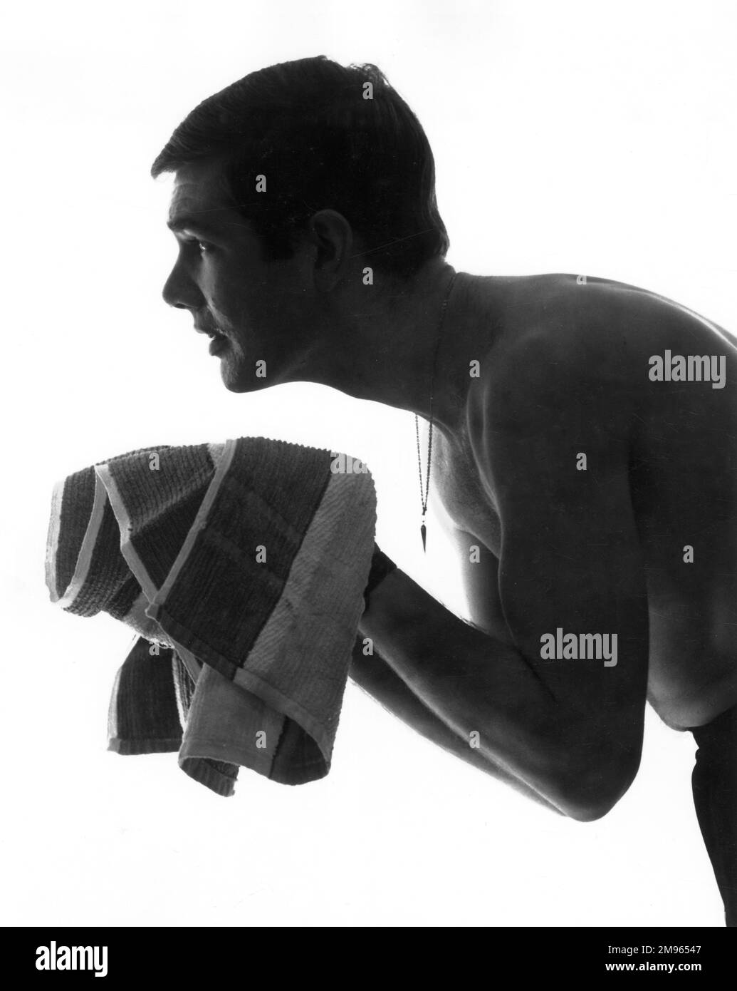 Profile of a man about to dry his face with a towel Stock Photo - Alamy