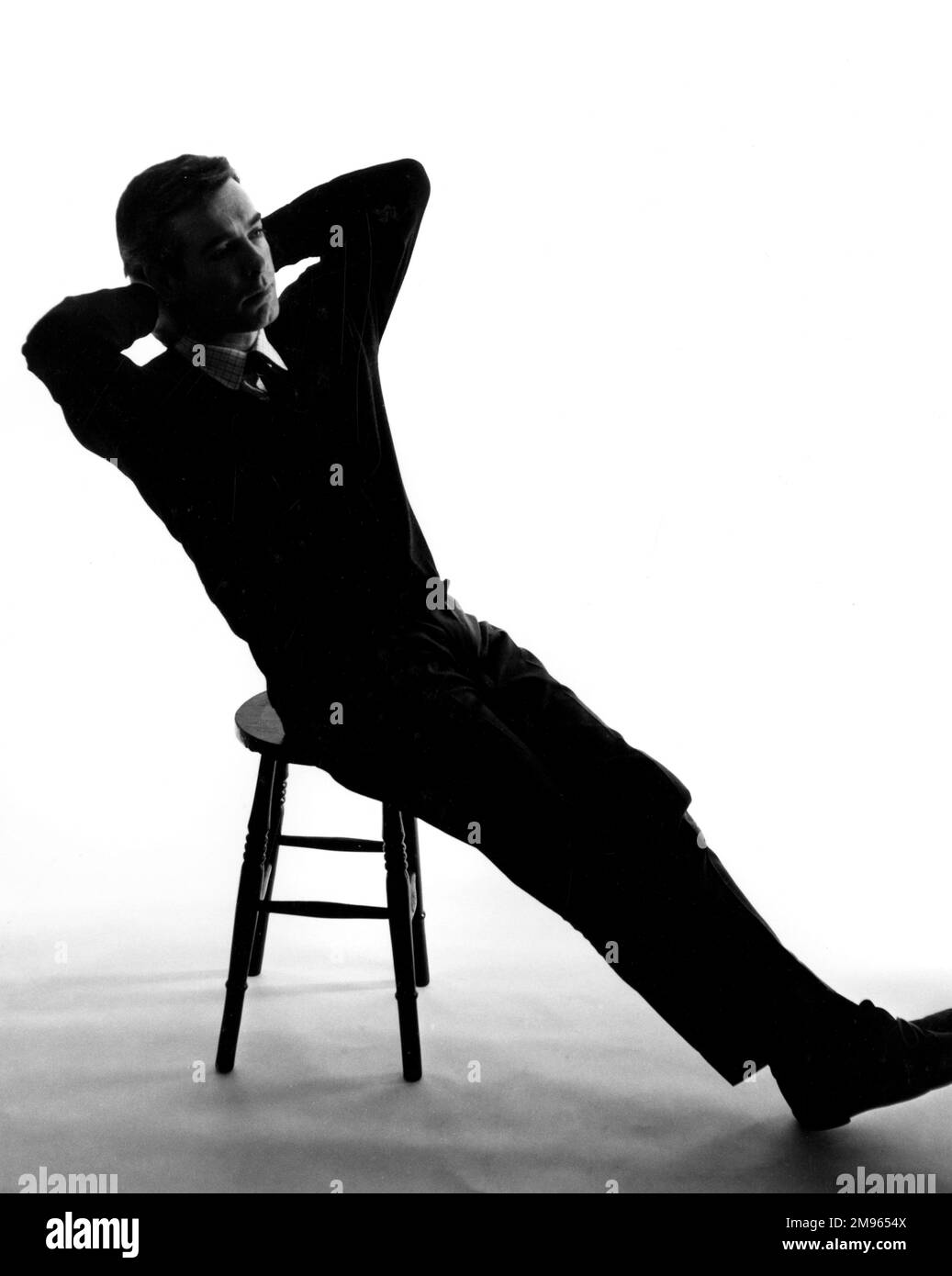 A young man poses on a stool Stock Photo - Alamy