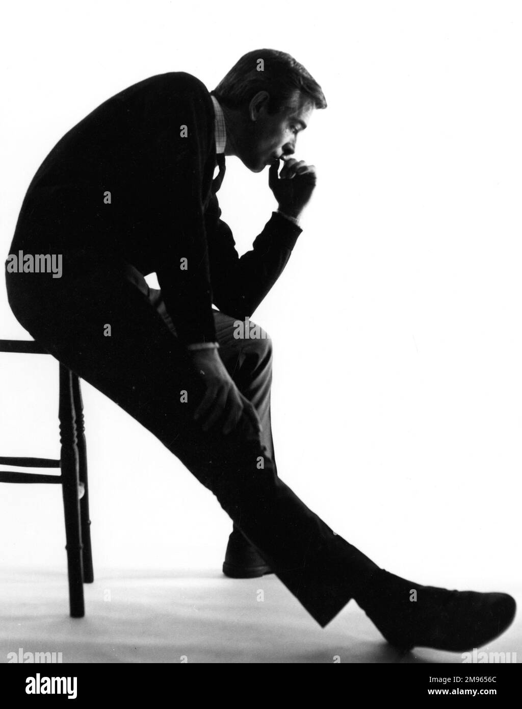 A young man poses on a stool Stock Photo - Alamy