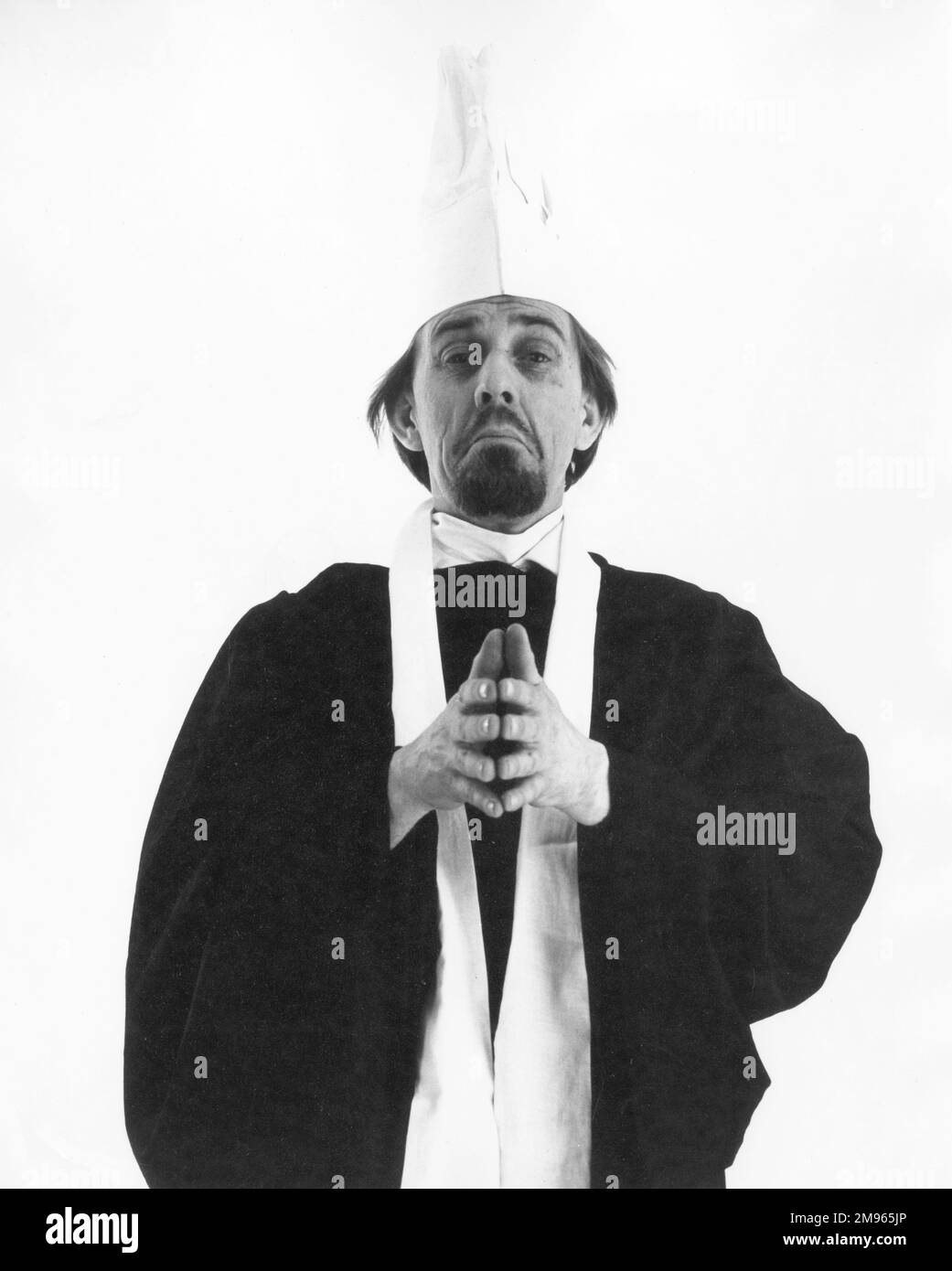 A priest (or chef?) with his hands together Stock Photo - Alamy