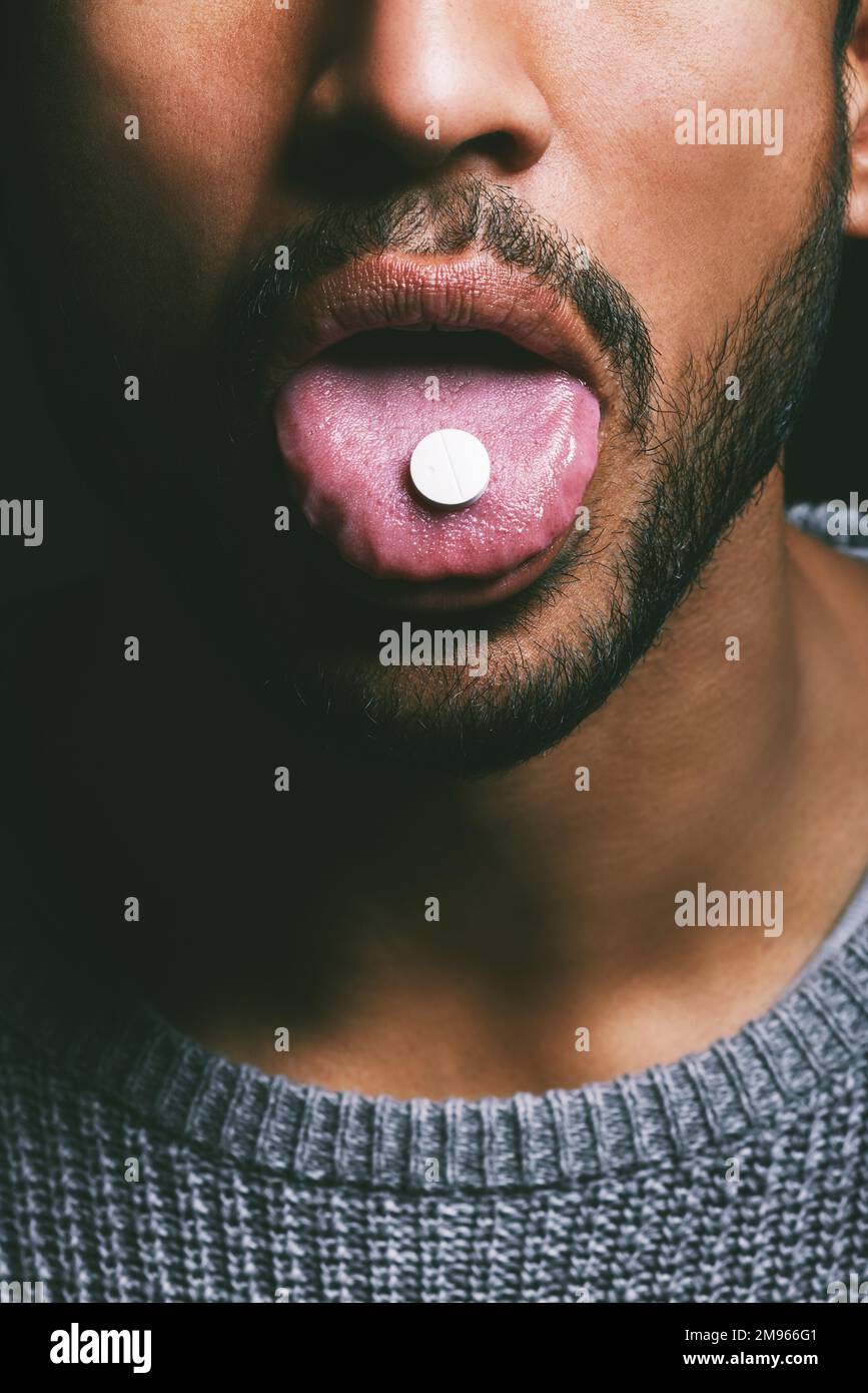Addiction looks like you and me. an unrecognisable man taking a pill ...