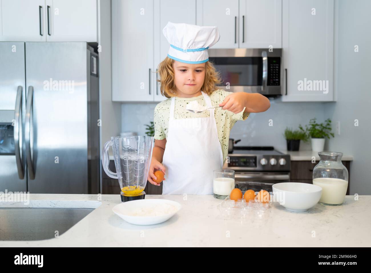 Kid chef cook wearing cooker uniform and chef hat preparing food on ...