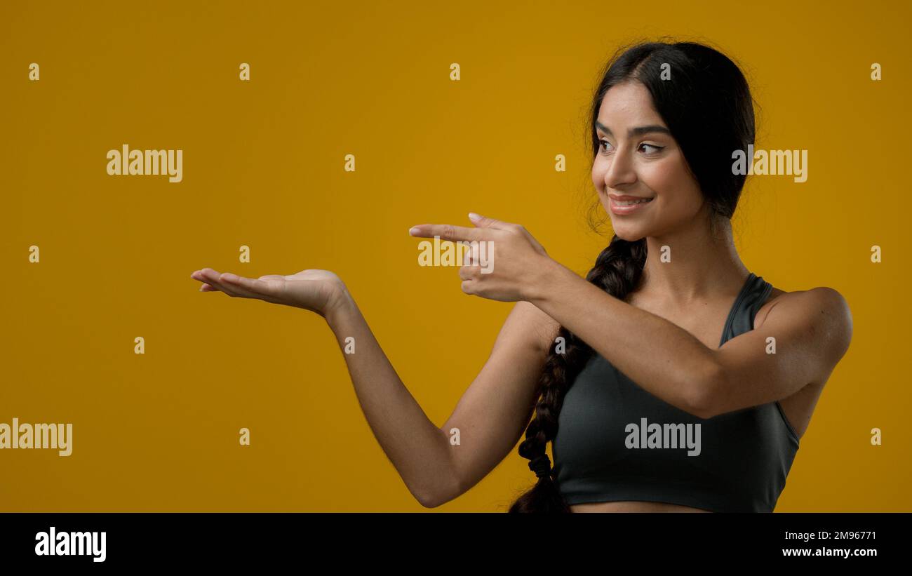 Portrait in studio Indian 20s woman posing on yellow background ...